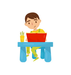 Cute red-haired boy sitting at table and eating Vector Image